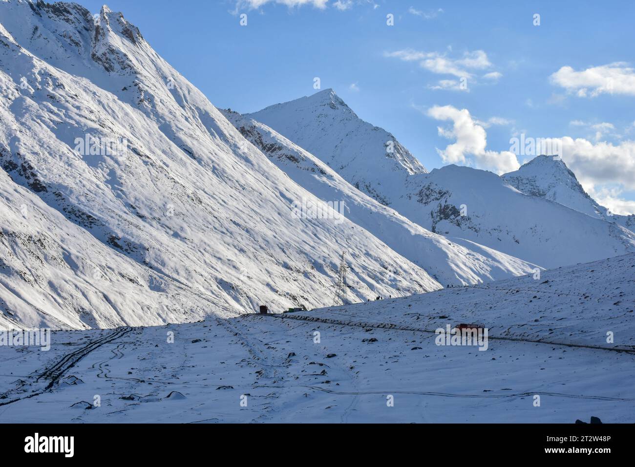 A truck carrying goods moves along the snow covered road in Drass, a ...