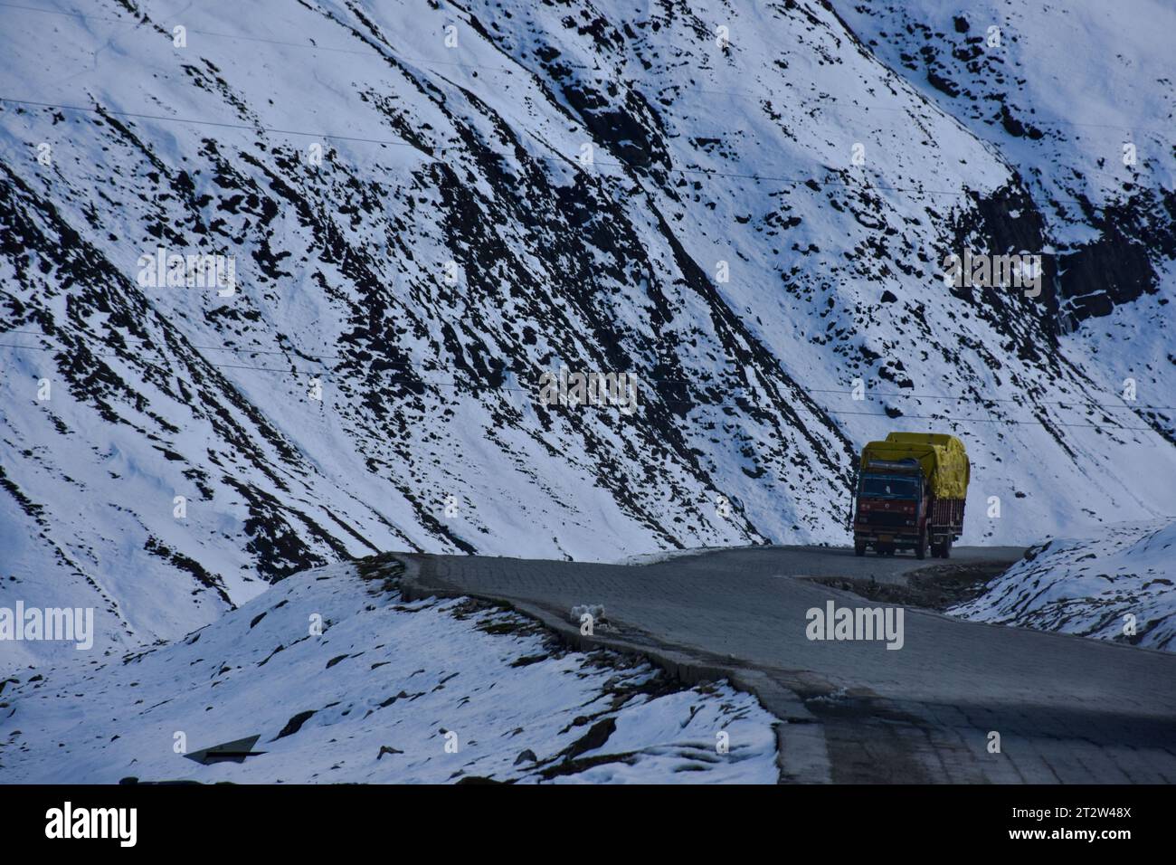 A truck carrying goods move along the snow covered road in Drass, a ...
