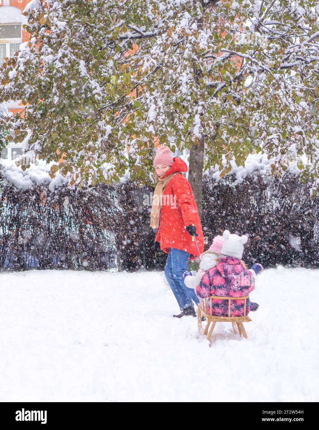Mother sledding her children. Family vacation in winter Stock Photo - Alamy