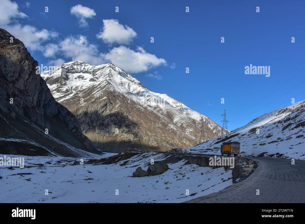 A truck carrying goods move along the snow covered mountains in Drass ...