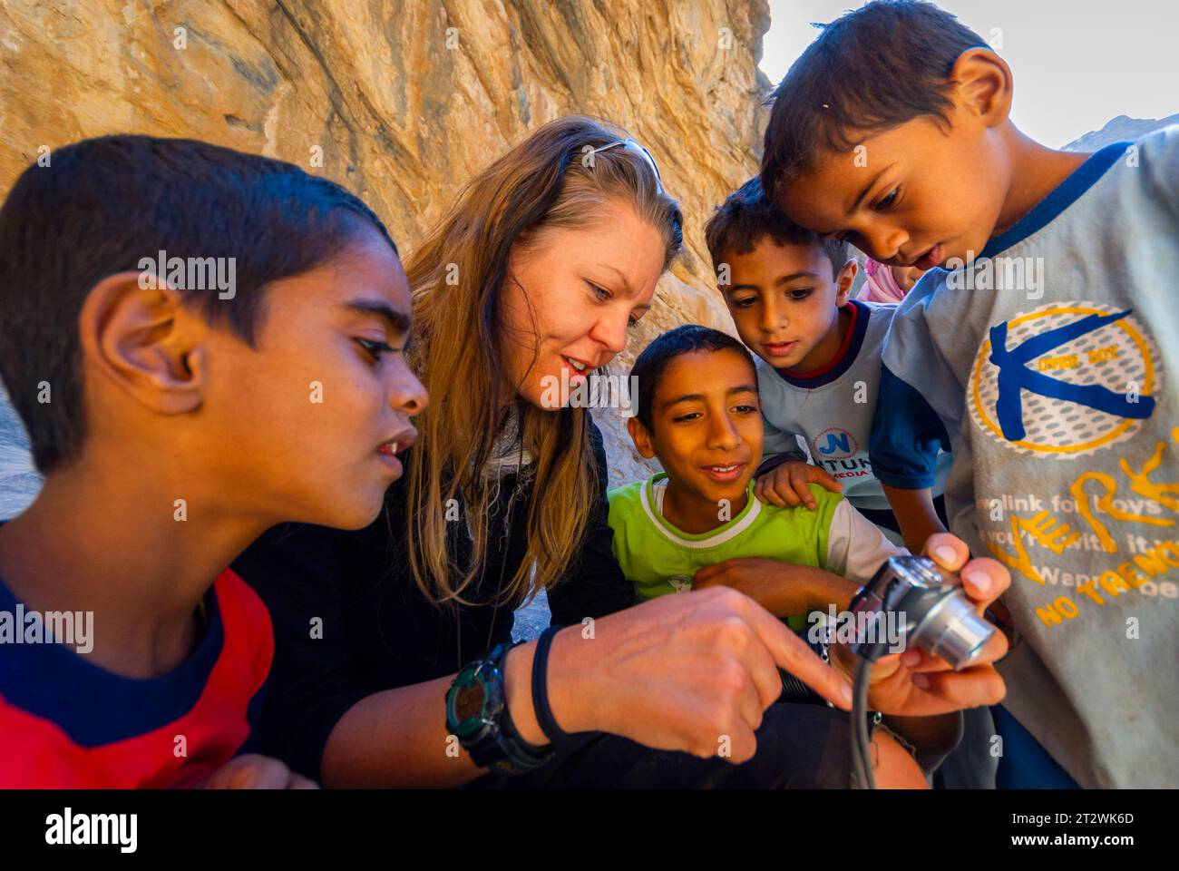A woman show digital photos to some village children near Balad Sayt in ...
