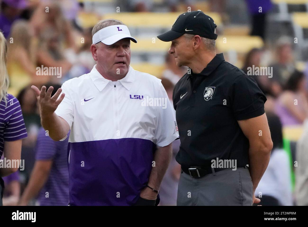 LSU head coach Brian Kelly, left, talks to Army head coach Jeff Monken ...