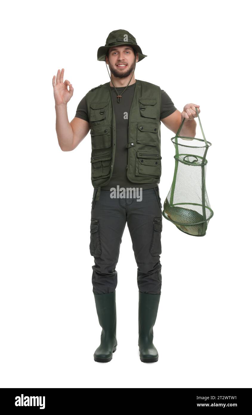 Fisherman holding fishing net with catch and showing ok gesture ...