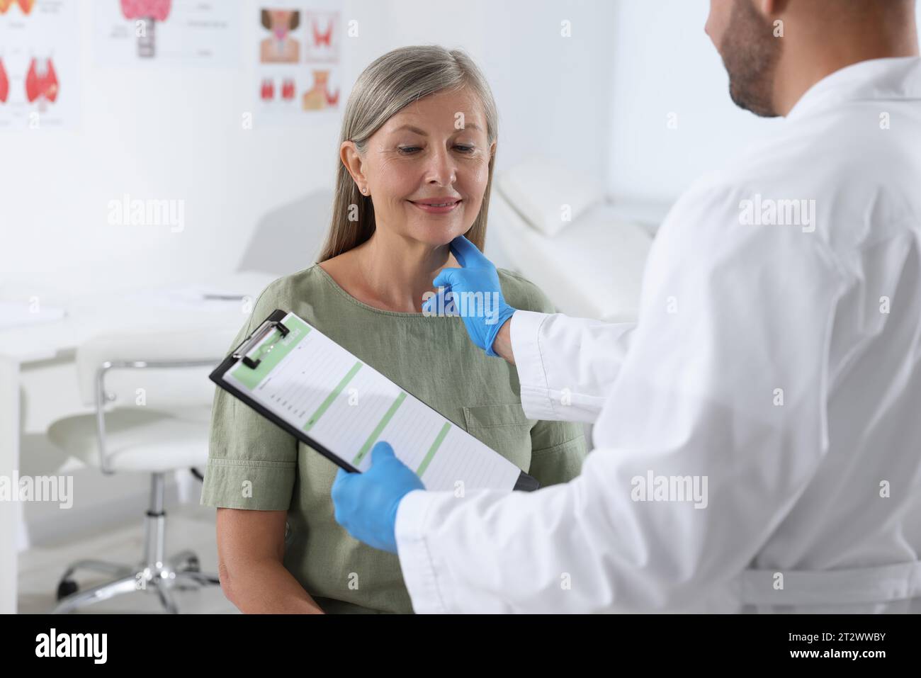 Endocrinologist examining thyroid gland of patient at hospital, closeup ...