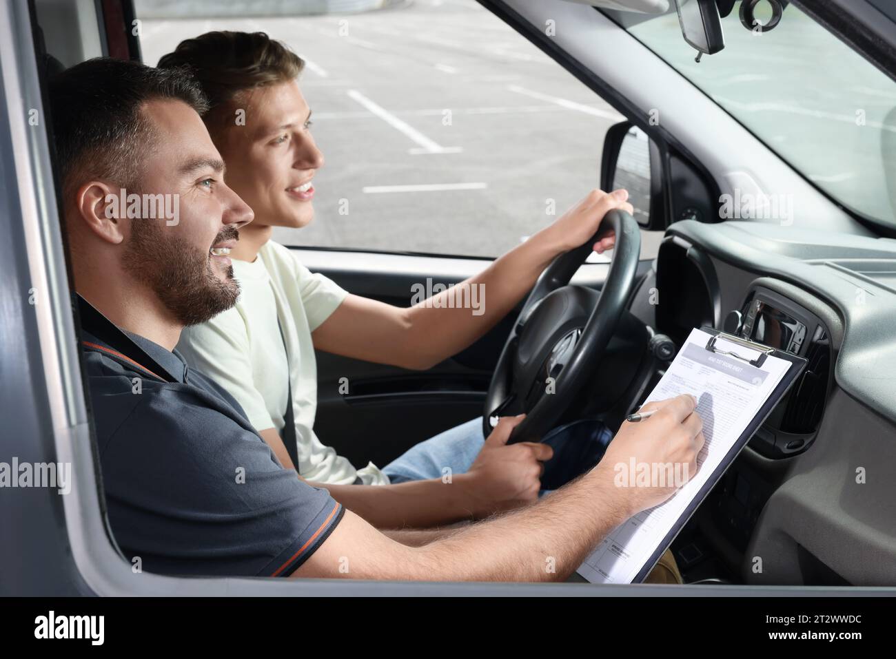 Driving school. Student passing driving test with examiner in car at ...