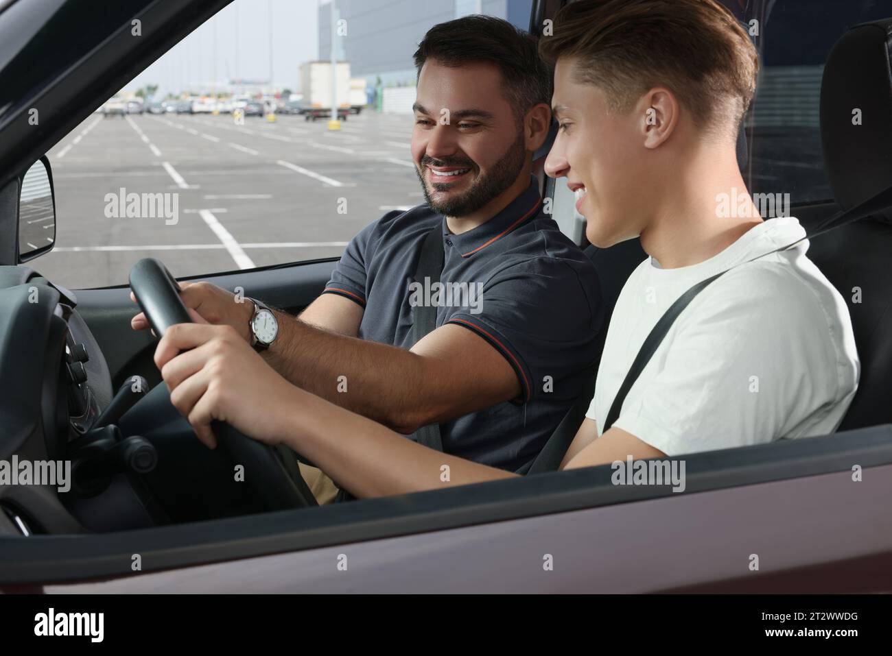 Driving school. Happy student during lesson with driving instructor in ...