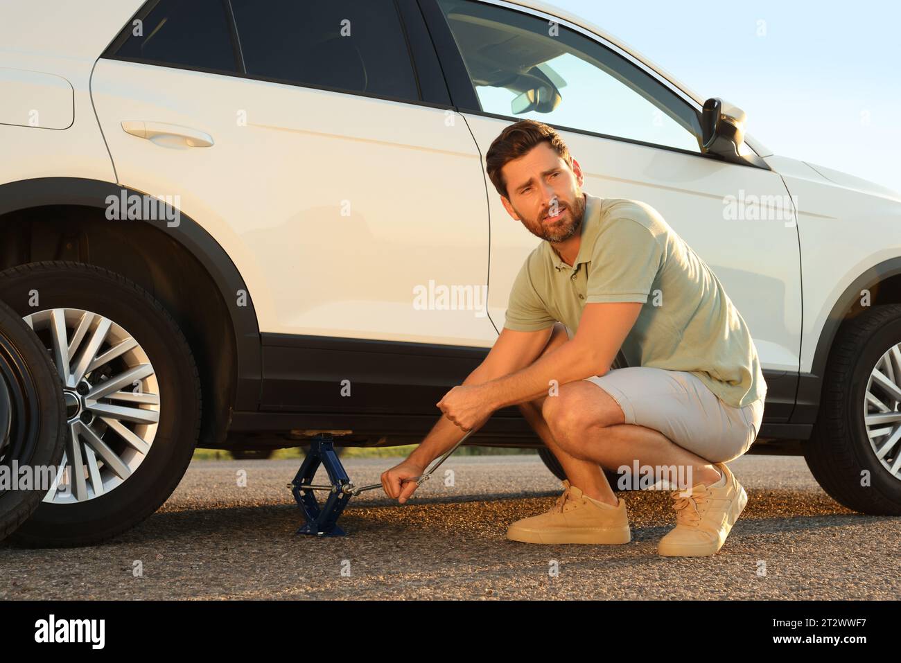 Man changing wheel of car on roadside Stock Photo - Alamy