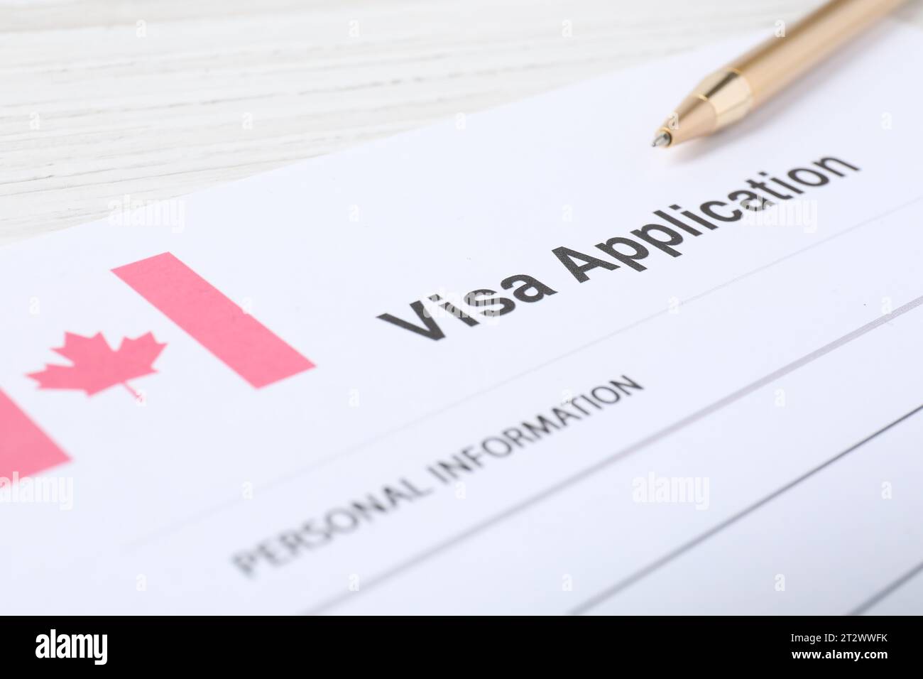 Immigration to Canada. Visa application form and pen on white wooden ...