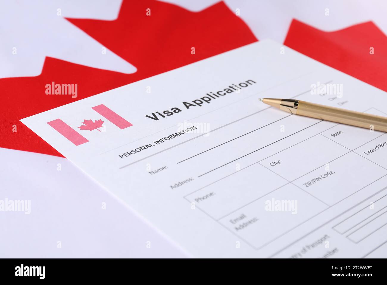 Immigration to Canada. Visa application form and pen on flag, closeup ...