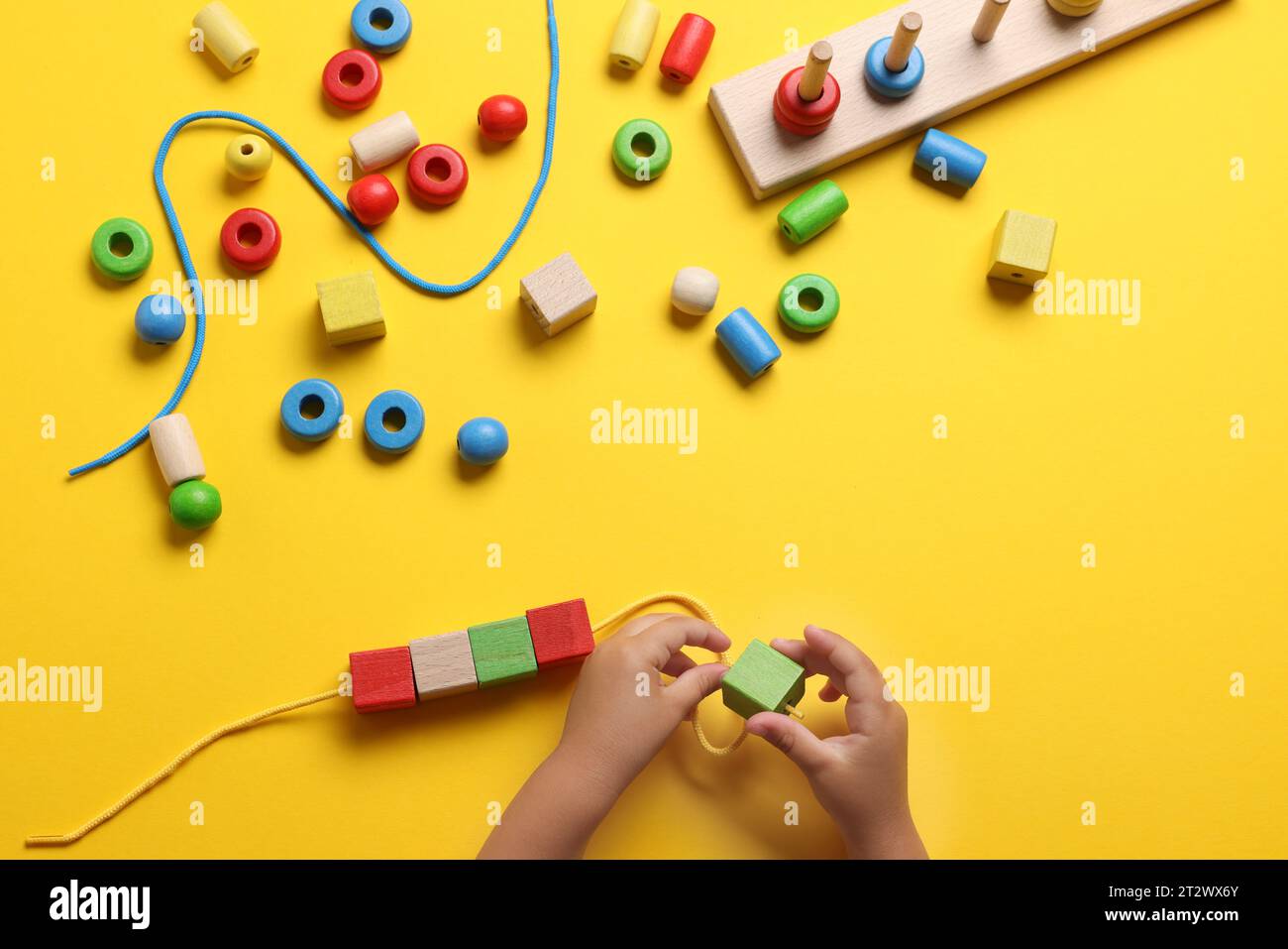 Motor skills development. Little child playing with wooden pieces and ...