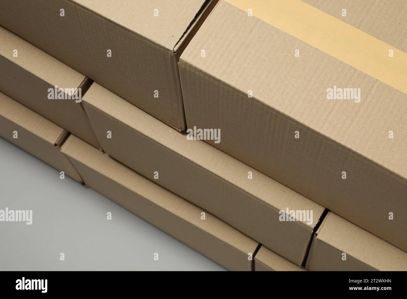 Stack of many closed cardboard boxes on light grey background, above ...