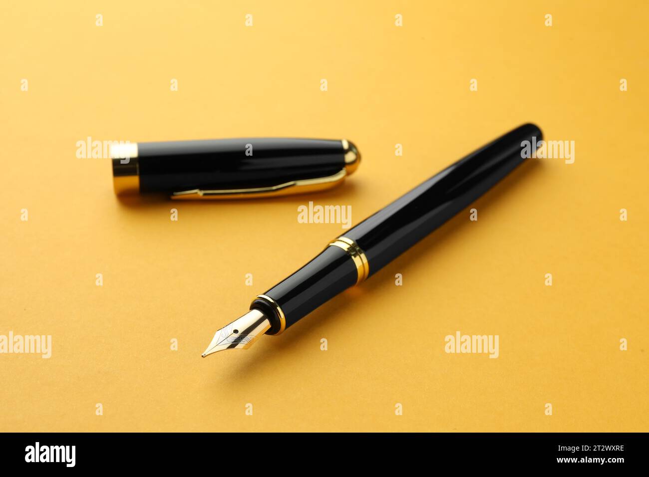 Stylish fountain pen with cap on yellow background Stock Photo - Alamy