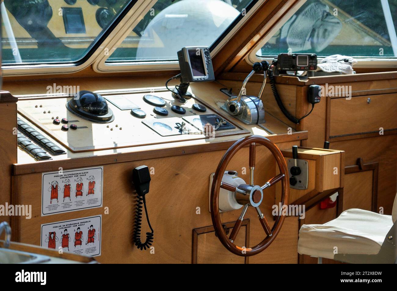 A boat cabin interior featuring a steering wheel and open windows Stock ...
