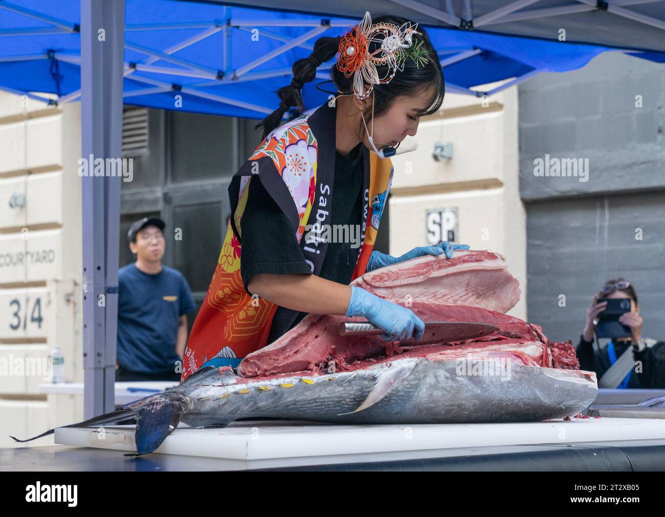 Members of Sabaki Girl Project perform bluefin tuna cutting during ...