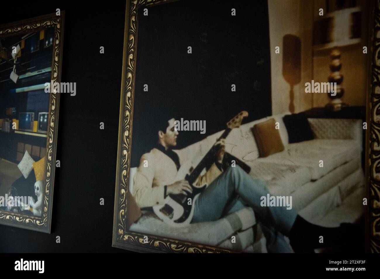A family photo of Elvis Presley sitting down playing guitar, displayed ...