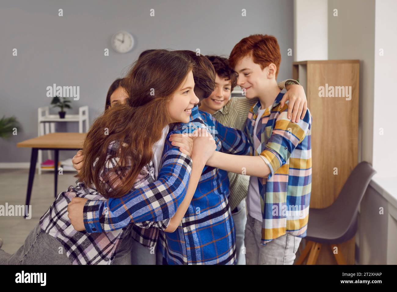 Group of happy school classmates and friends standing in the classroom ...