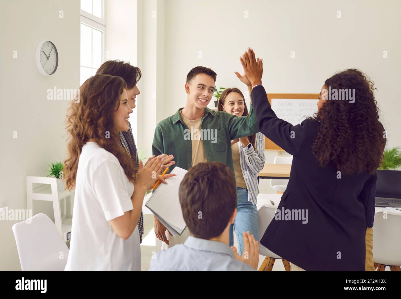 Happy high school students and classmates giving high five when they ...