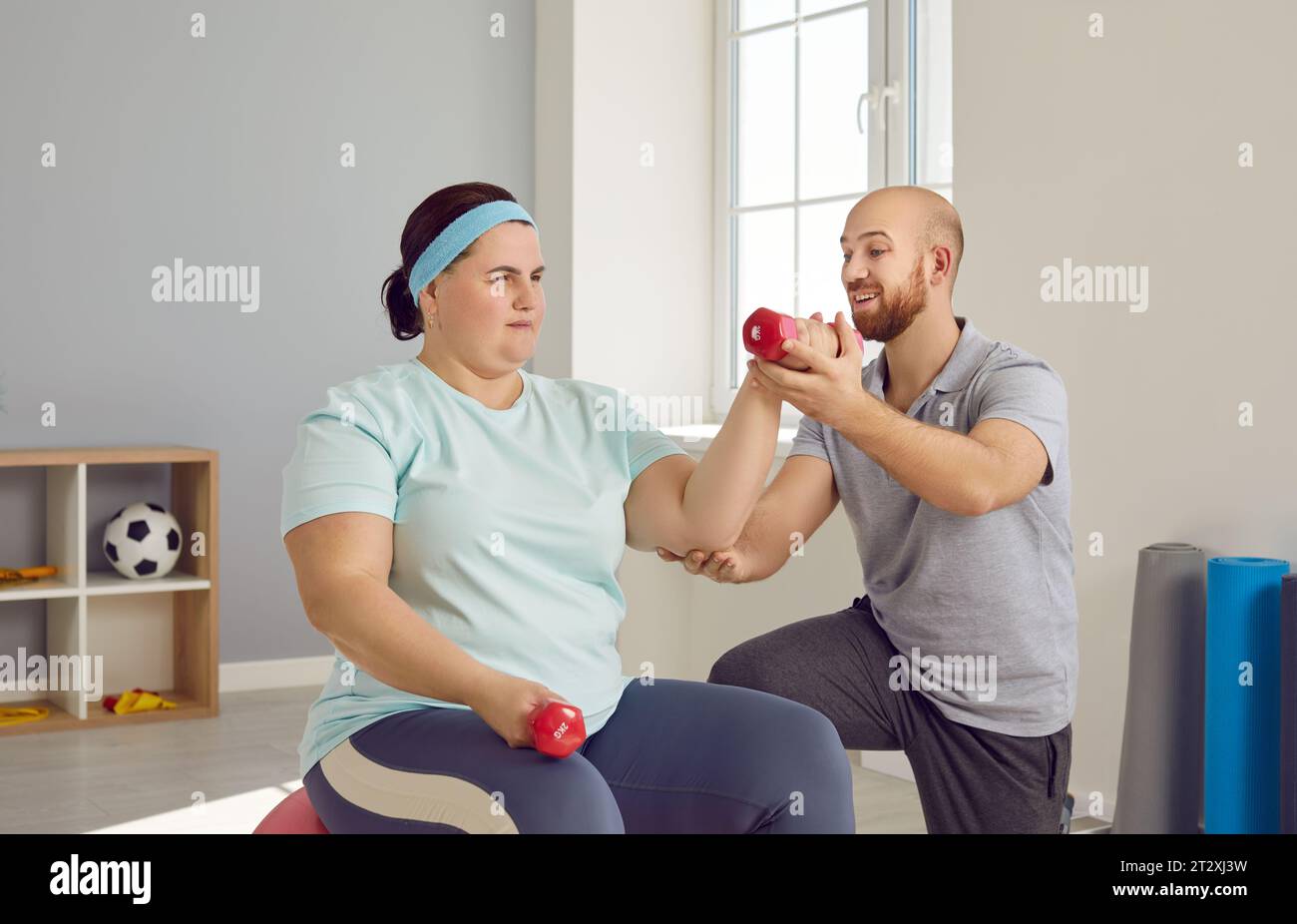 Fat woman doing fitness workout with her trainer for in fitness club ...