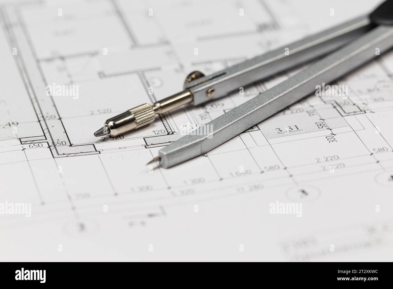 A drawing compass lies on the drawing.Close-up with shallow depth of ...