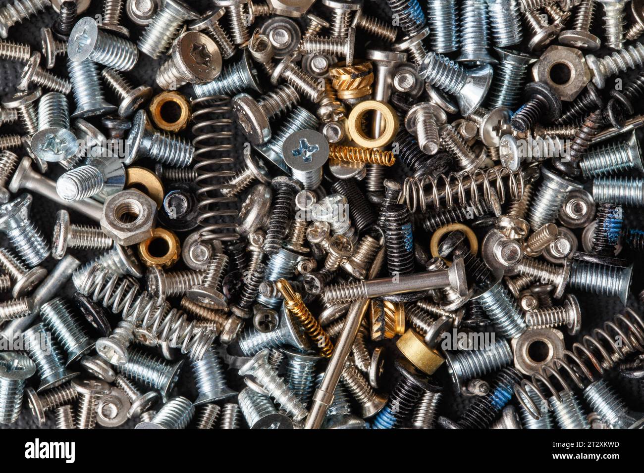 Various fasteners, bolts, nuts, screws, springs piled up in a heap ...