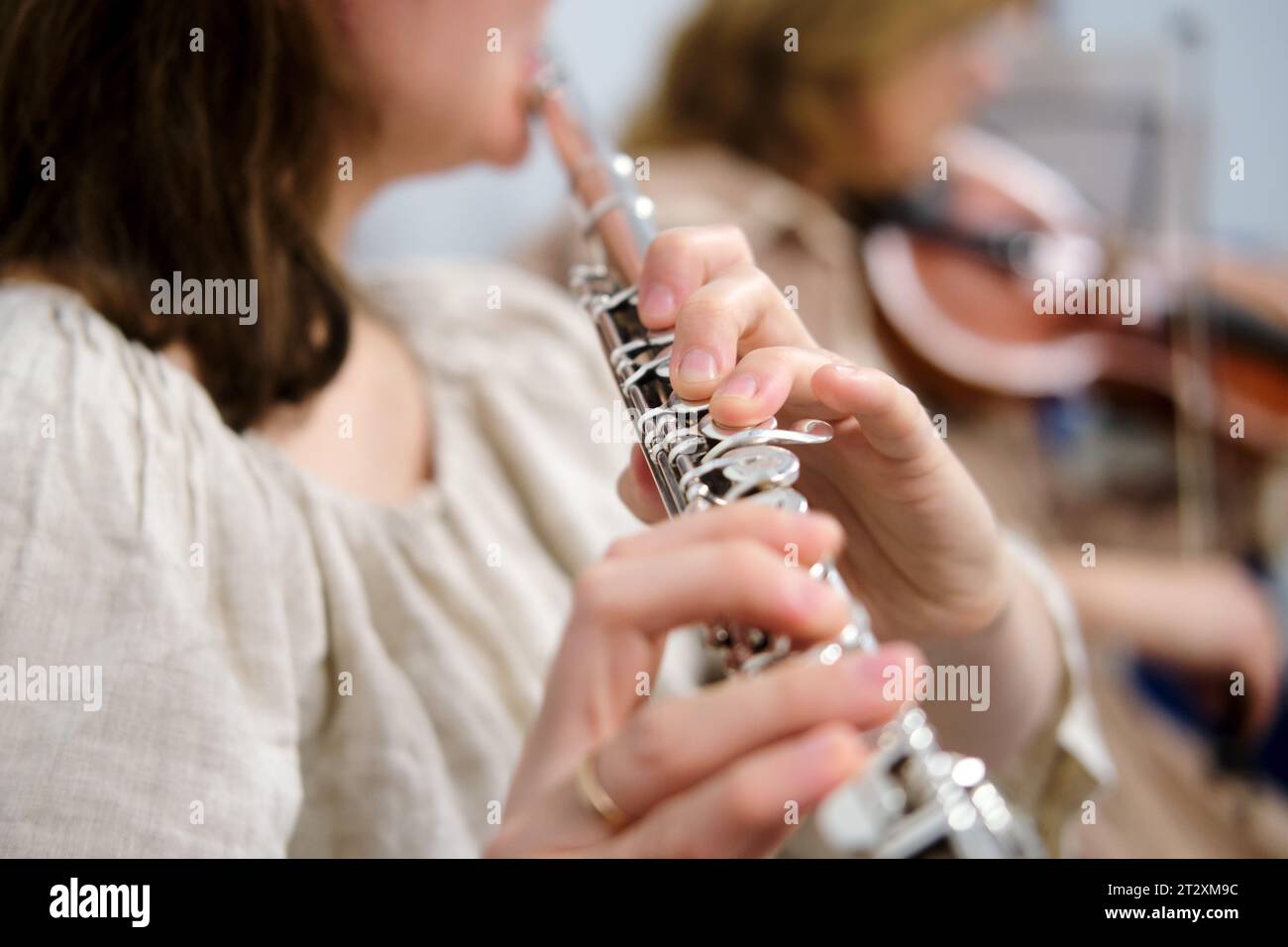 The flautist's hand, seen in macro view, gracefully glides along the ...