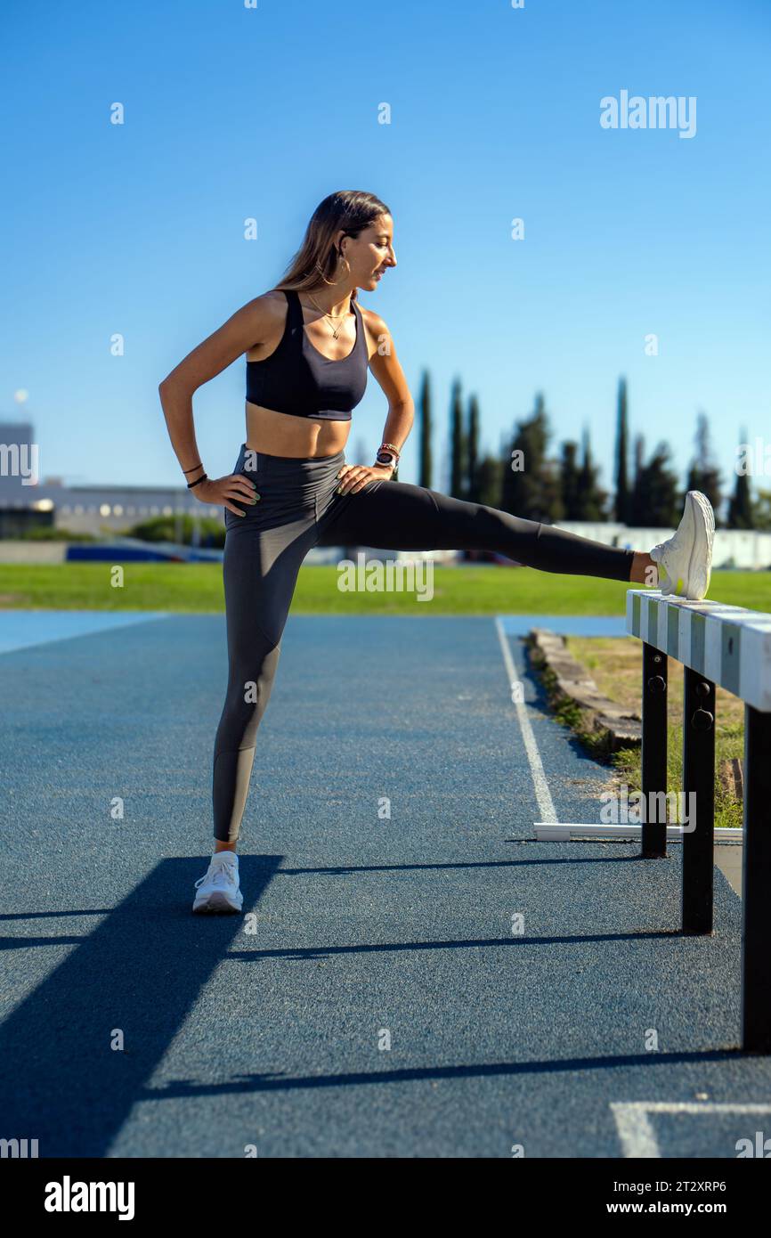 Beautiful young runner, tanned with long dark hair, smiling and ...