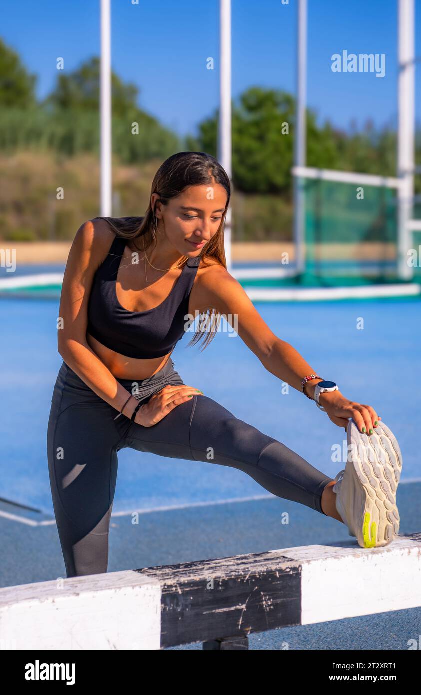 Beautiful slim young runner girl, tanned with long hair, concentrated ...