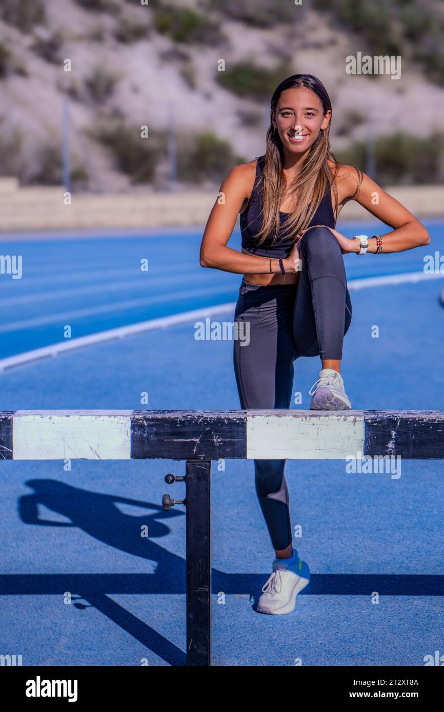 Beautiful young runner girl, tanned with long brown hair, smiling with ...