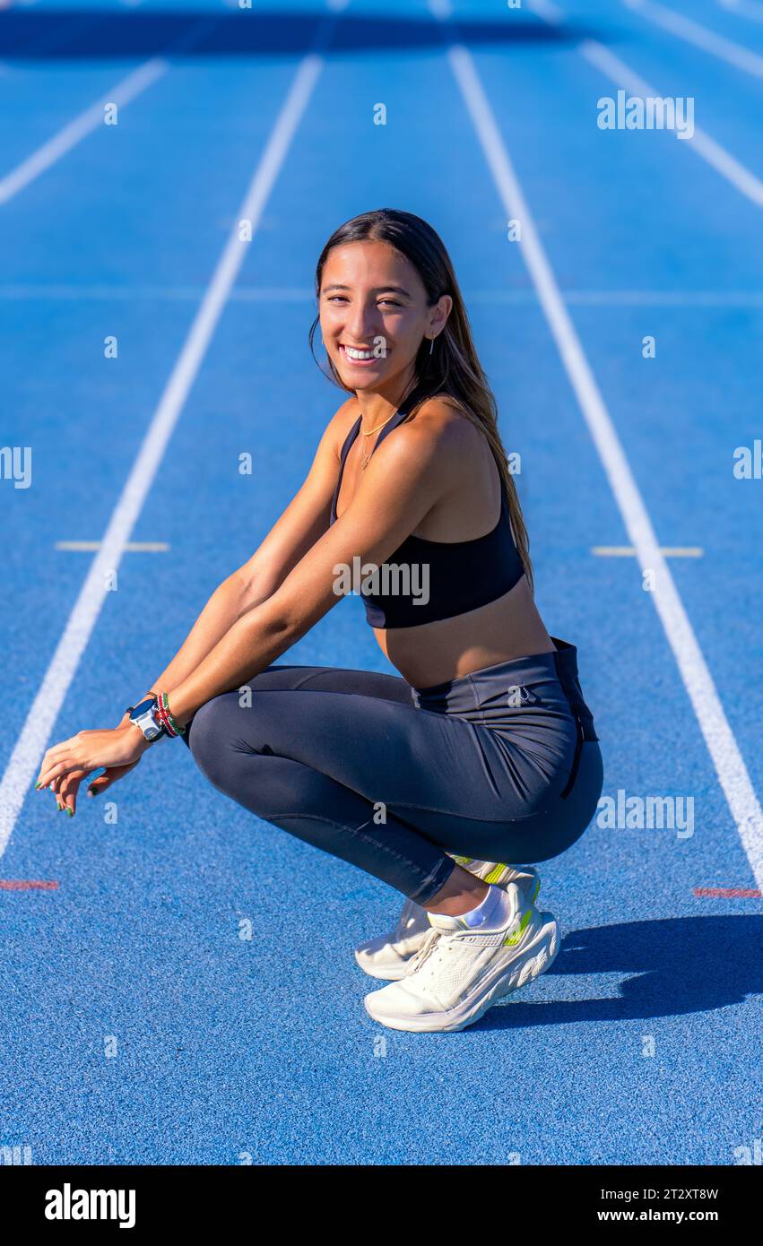 Beautiful young runner girl, tanned with long dark hair, sitting ...