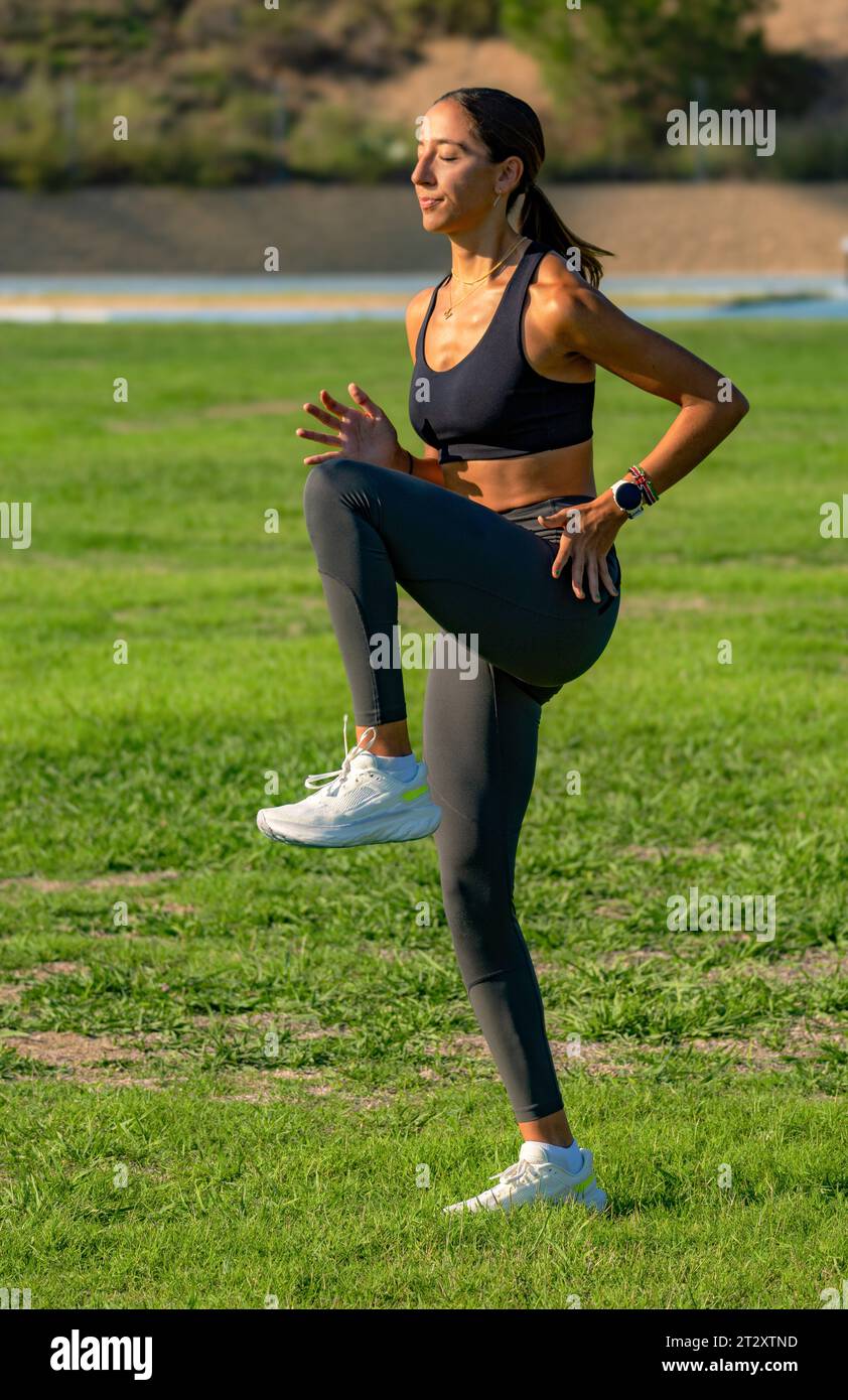 Beautiful young slim, tanned runner with long hair tied in a ponytail ...
