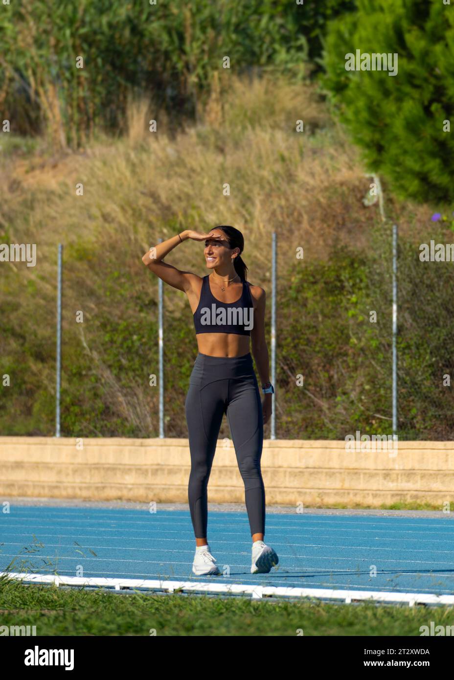 Beautiful young tanned woman with toned athletic body dressed in a top ...