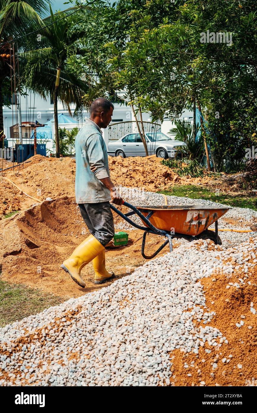 Selangor, Malaysia - October 21, 2023 Workers using wheelbarrow at a ...