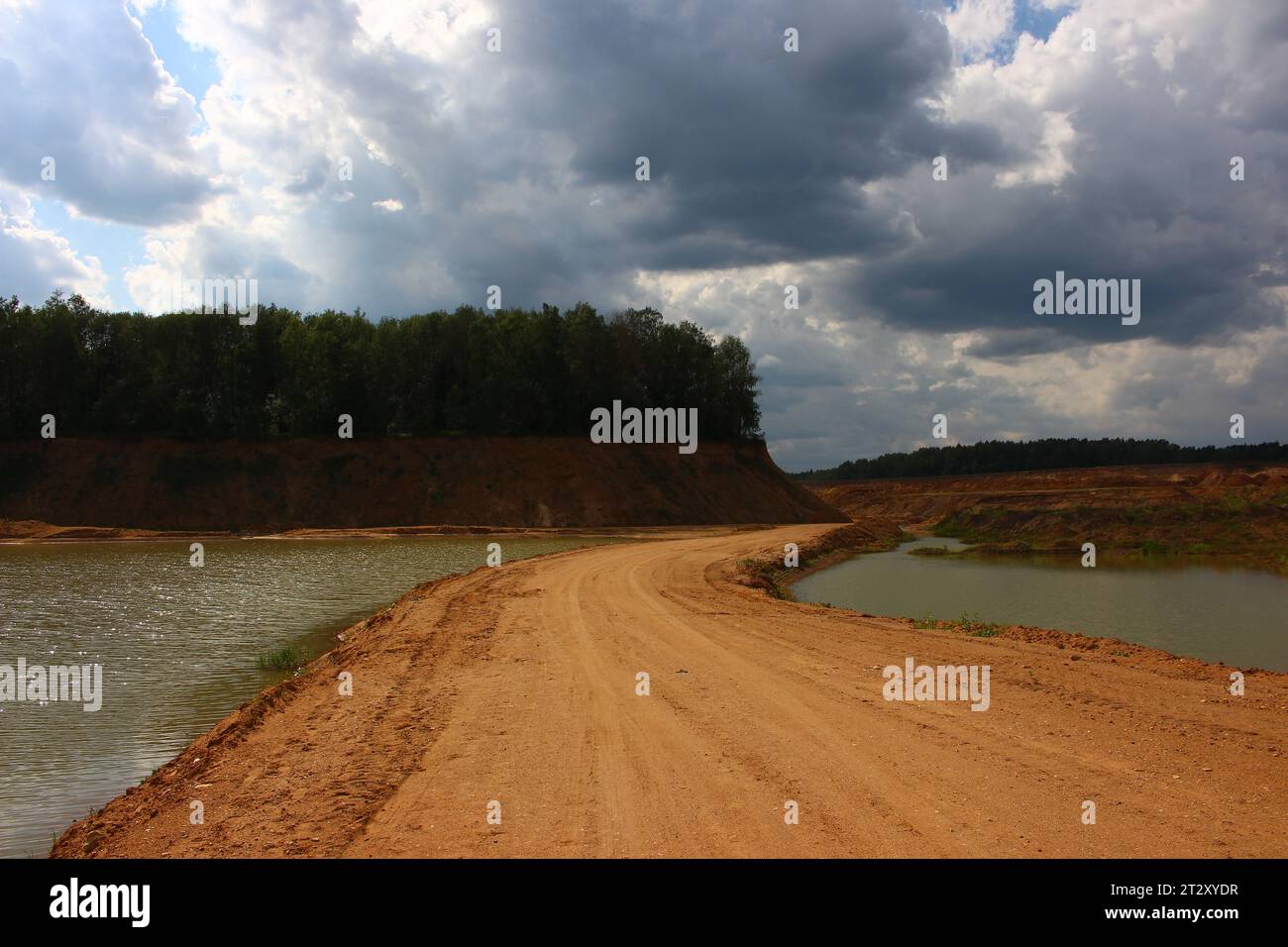 Sandy embankment road for trucks on a flooded sand quarry Stock Photo ...