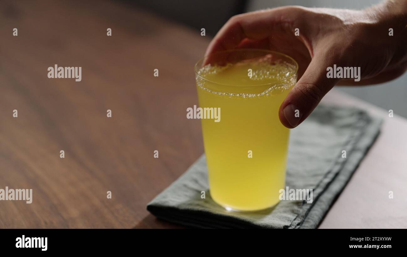 man hand take lemonade in tumbler glass on wood table , wide photo ...