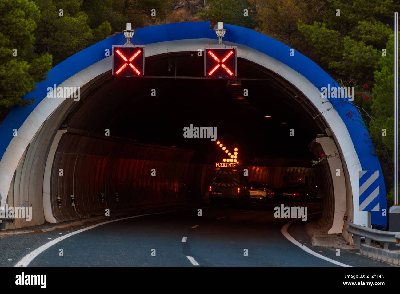 Tunnel on a highway with light signs warning of closed lanes, with a ...