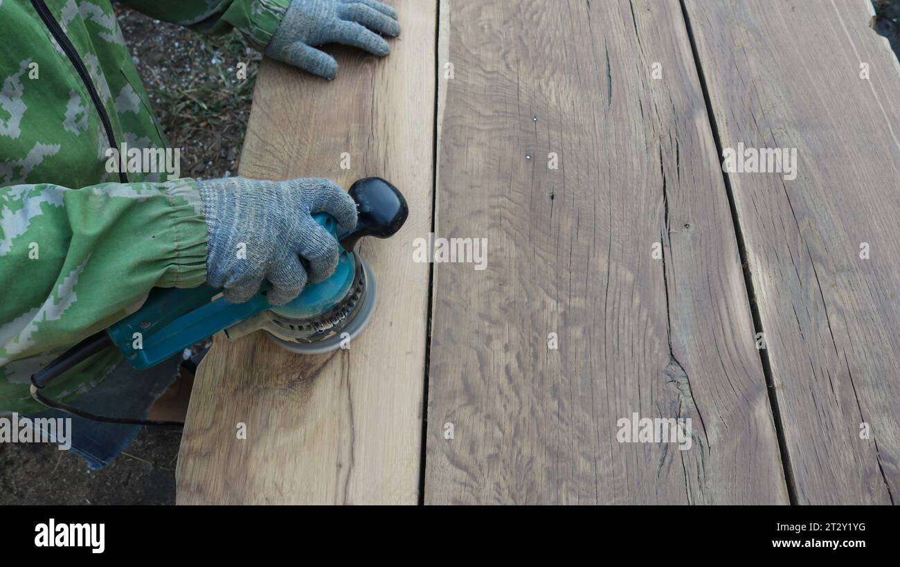 solid wood in the process of sanding a textured surface using an emery ...