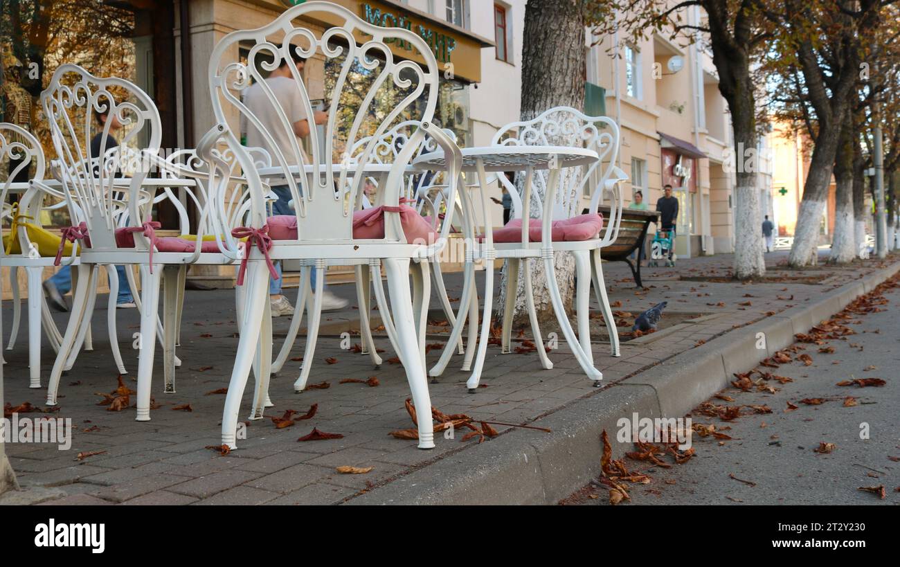 white elegant restaurant furniture on a pedestrian autumn street in the ...