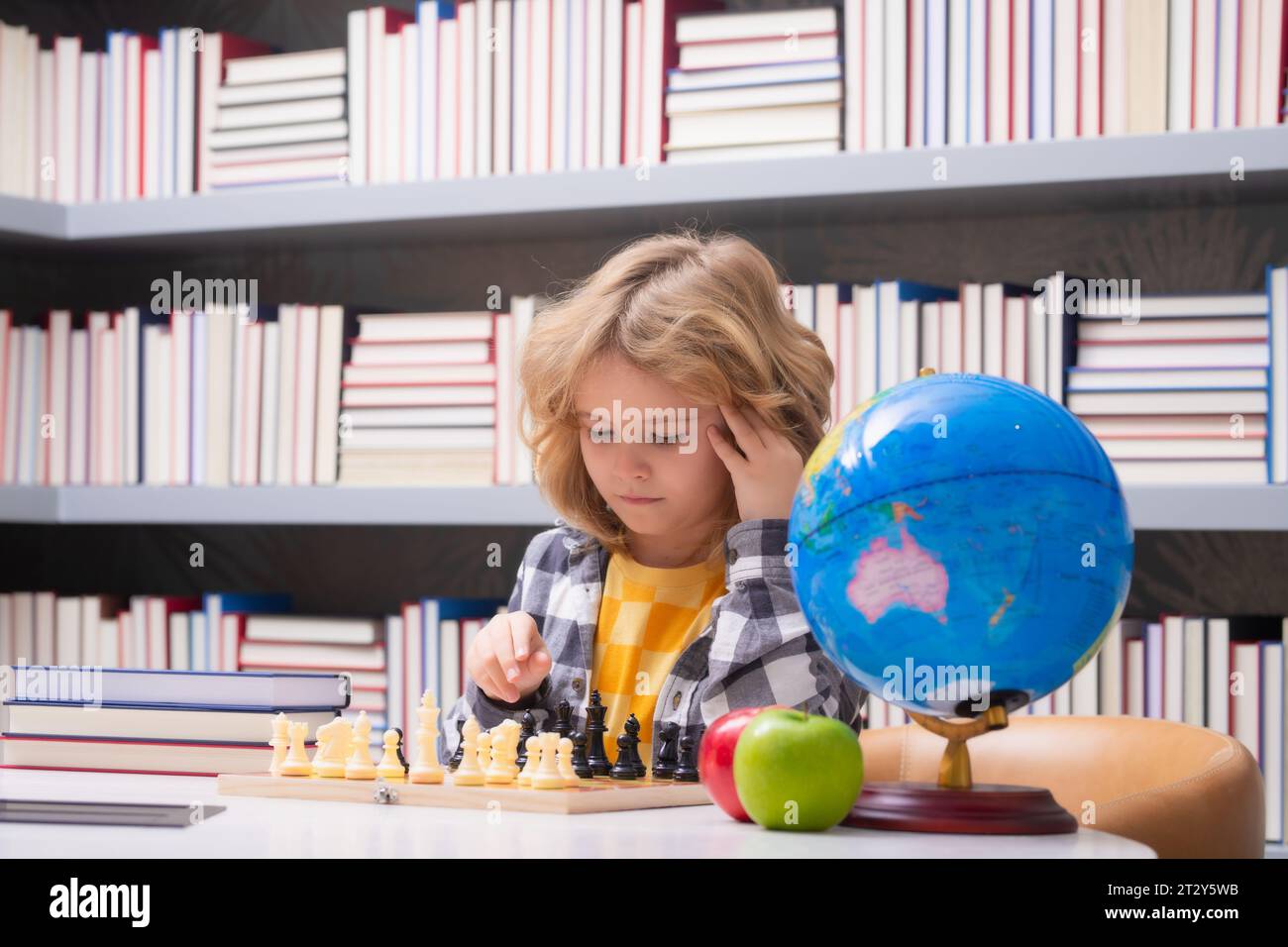 Child play chess. Clever concentrated and thinking child playing chess ...