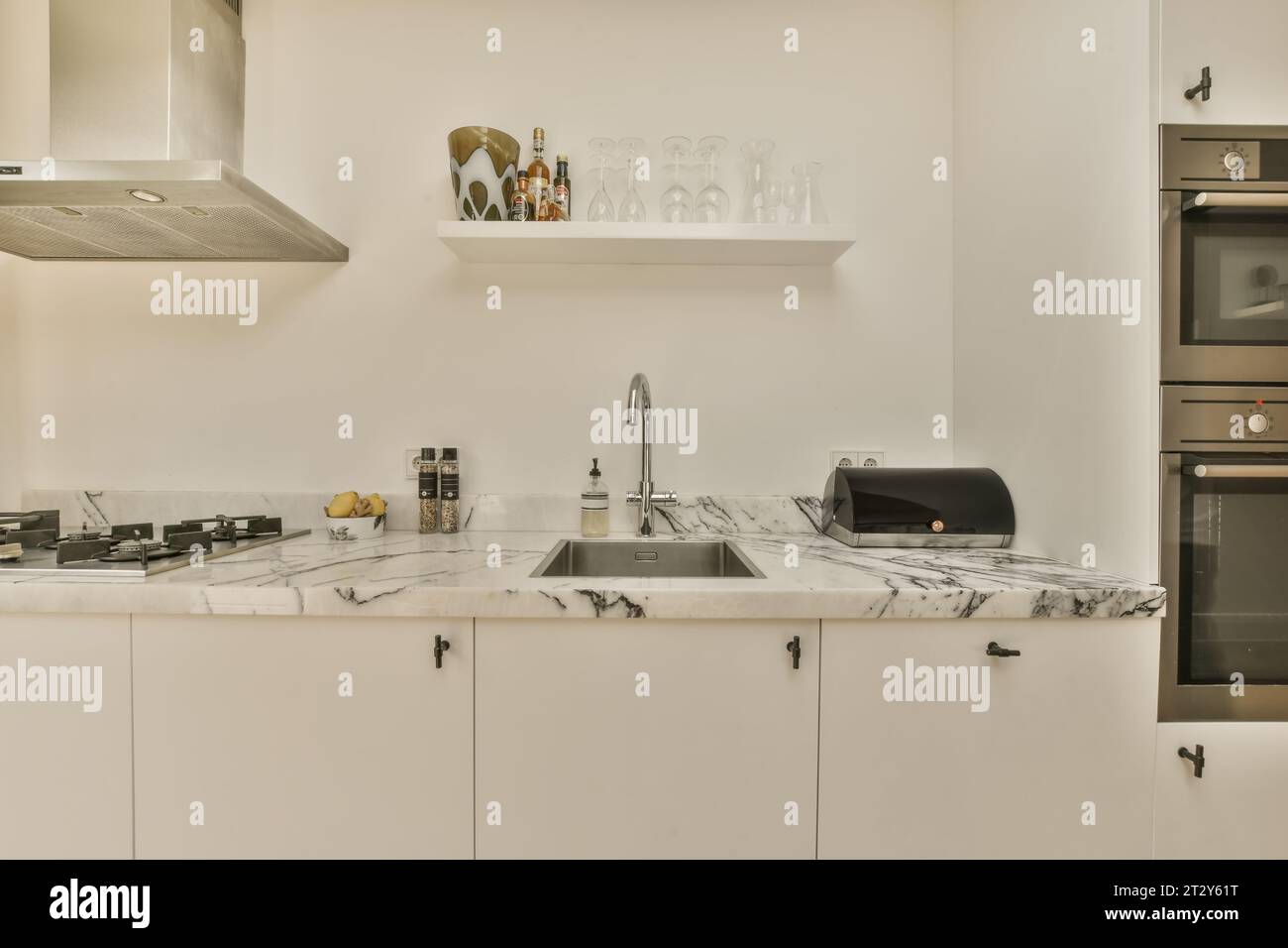 a modern kitchen with marble counter tops and white cabinets in the ...