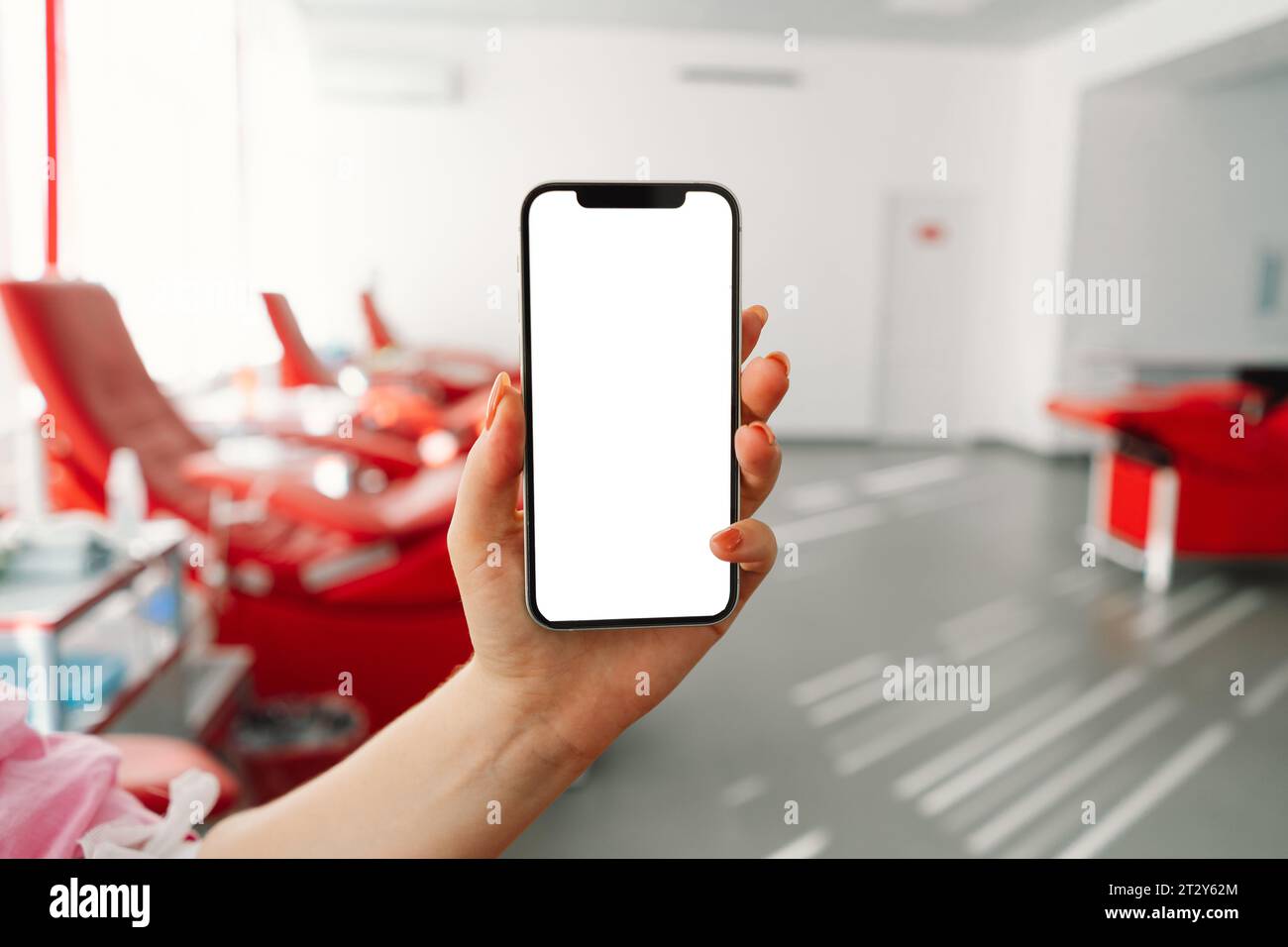 Close up of female hand holding phone with blank screen at blood ...