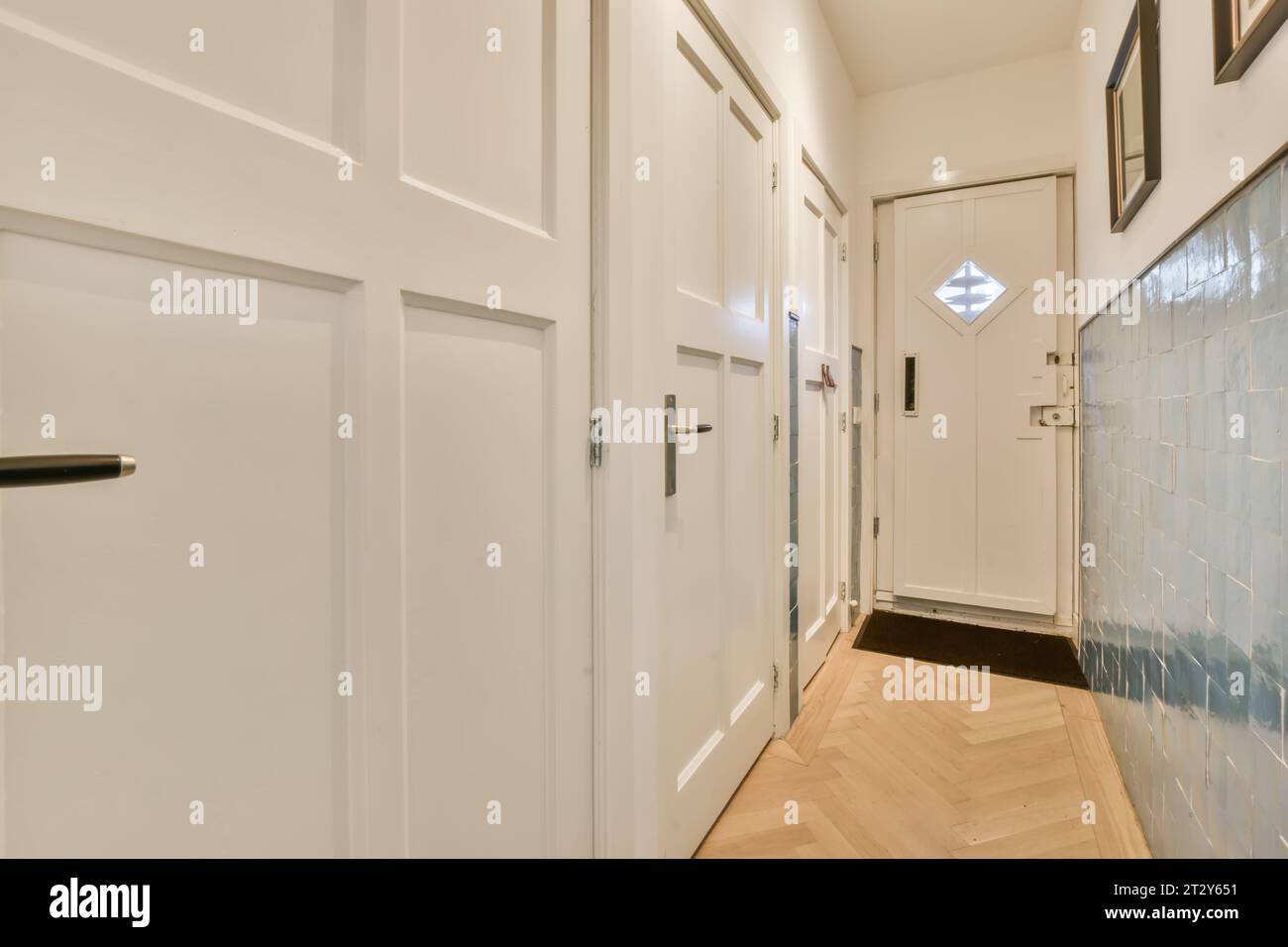 a long hallway with white walls and wood flooring on the left handrails ...