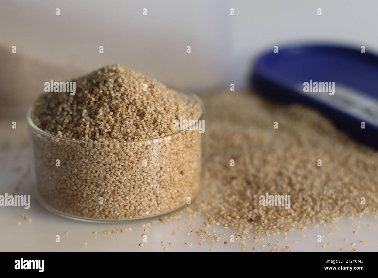 Closeup of little millet grains in a storage container and glass bowl ...