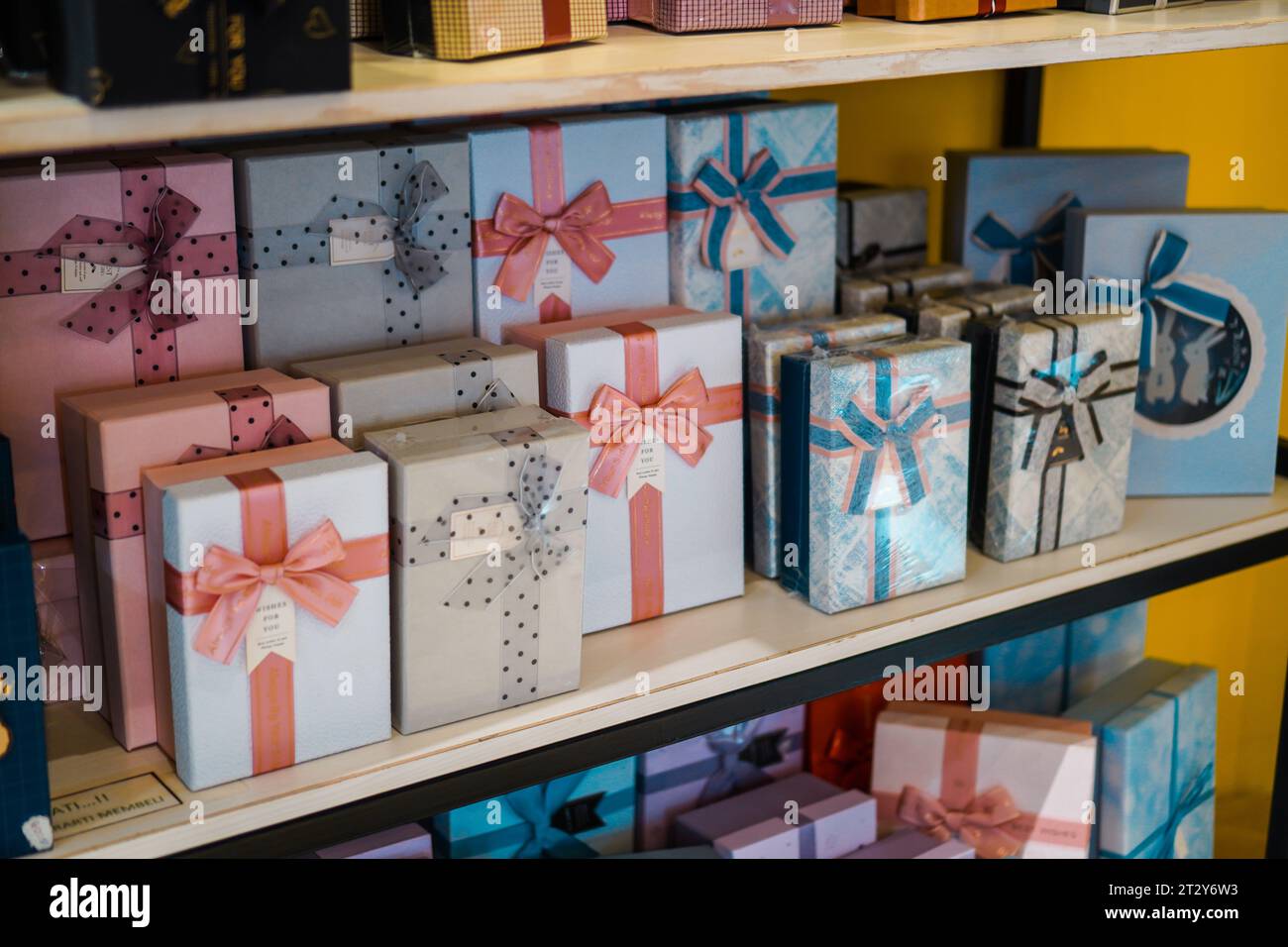 Colorful and patterned gift box stacks arranged on multi-tiered shelves ...