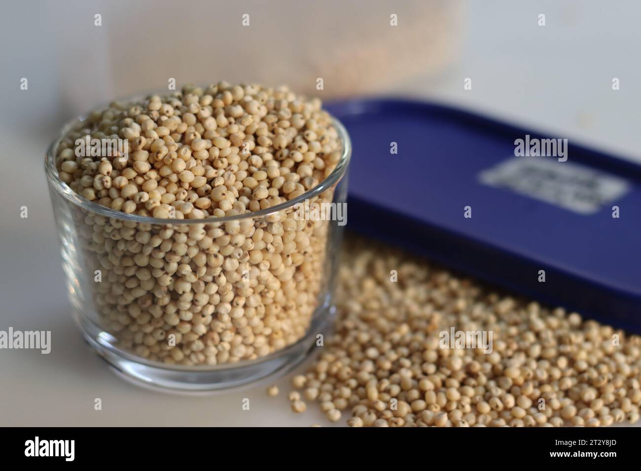 Closeup of sorghum millet grains kept in a storage container and glass ...