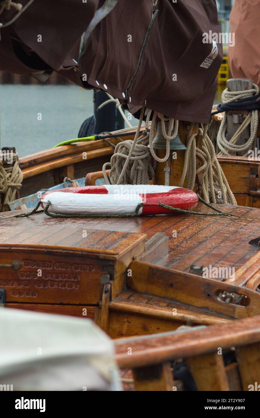 Sideview of a Lifebelt on wooden Deck of an old sailing vessel. Ropes ...
