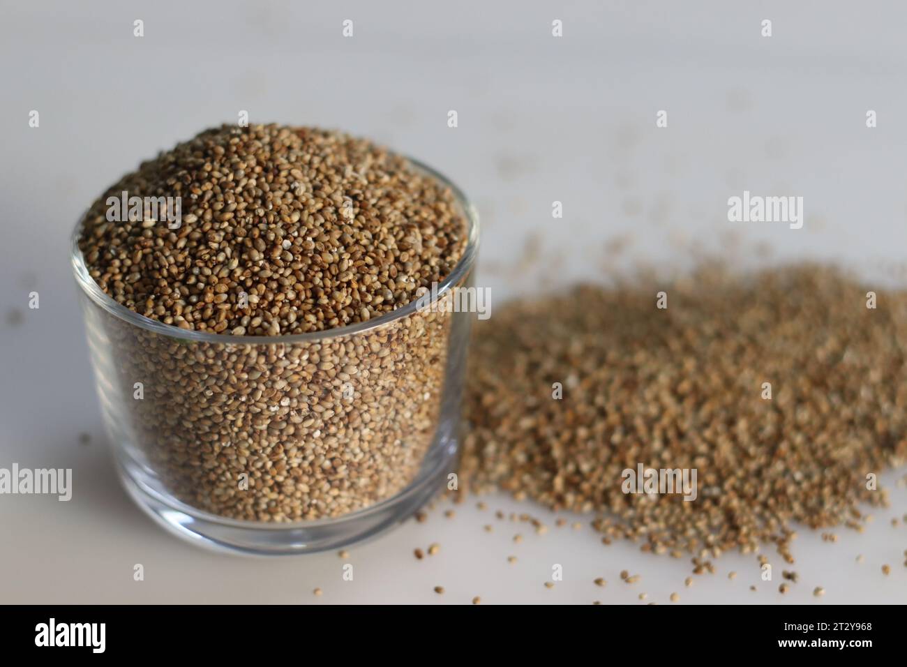 Pearl millet grains in a glass bowl filled to the brim, showcasing ...