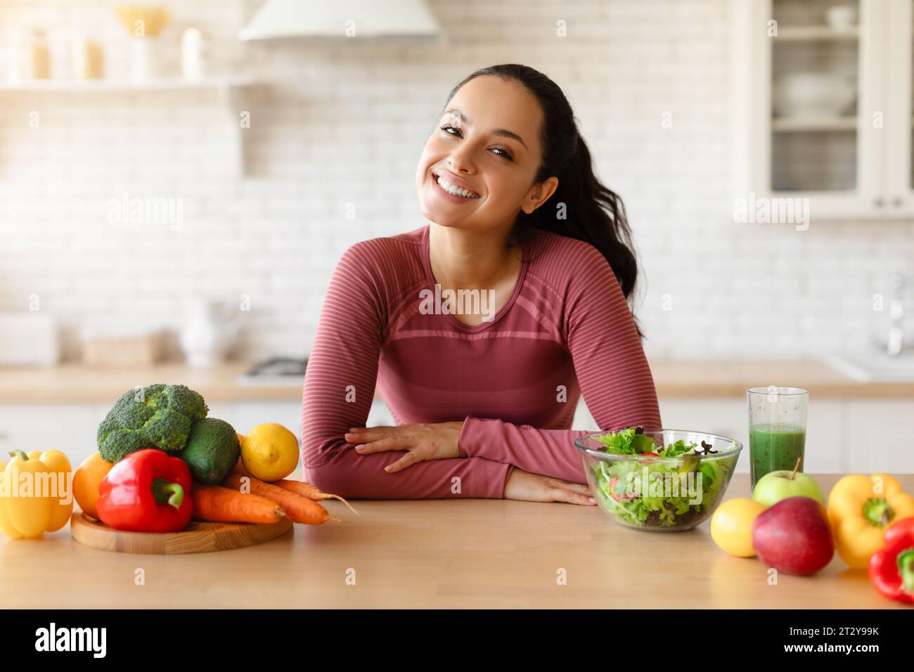 Beautiful fit woman after fitness workout leaning on tabletop indoor ...