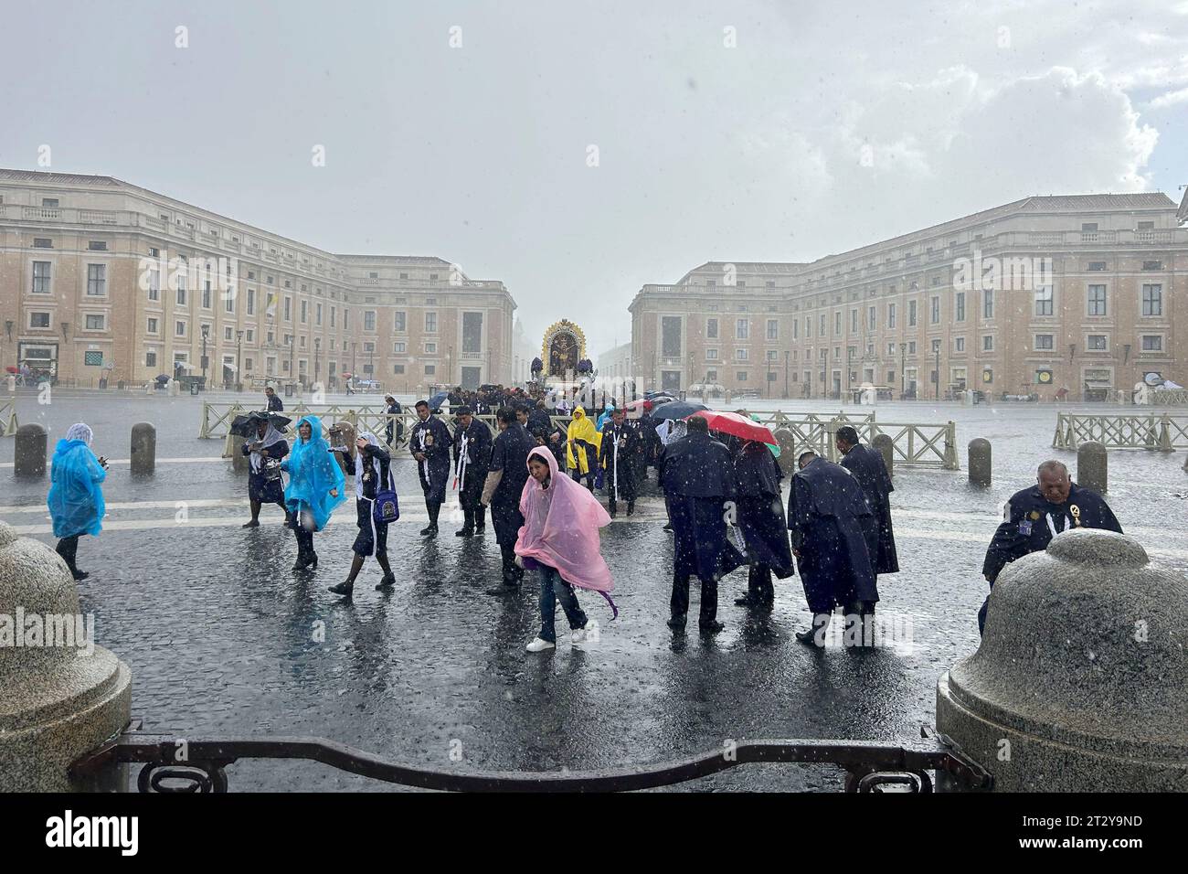 Faithful take shelter from a sudden rain shower prior to the start of ...