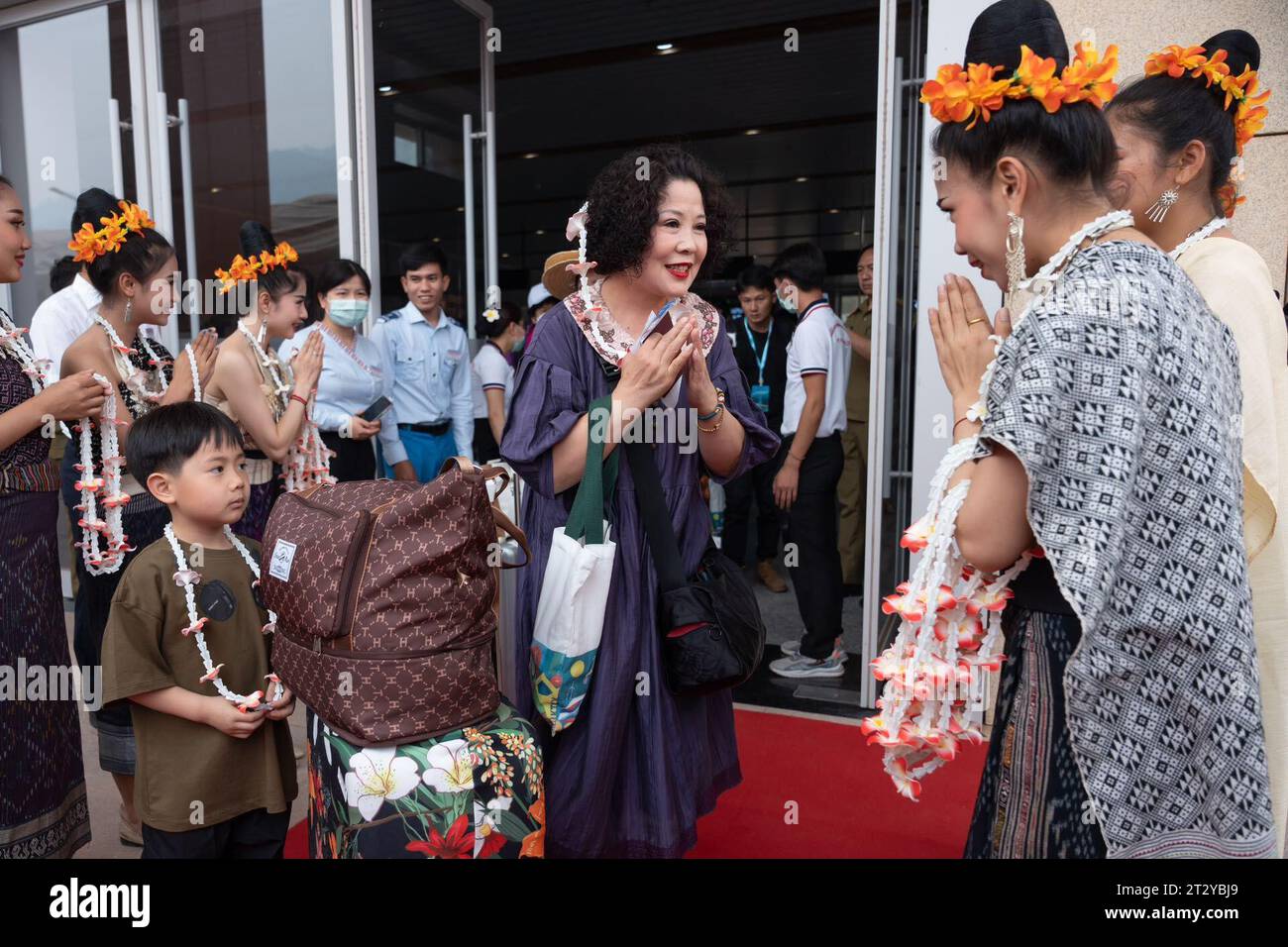 Beijing, Laos. 13th Apr, 2023. Lao staff members greet passengers ...