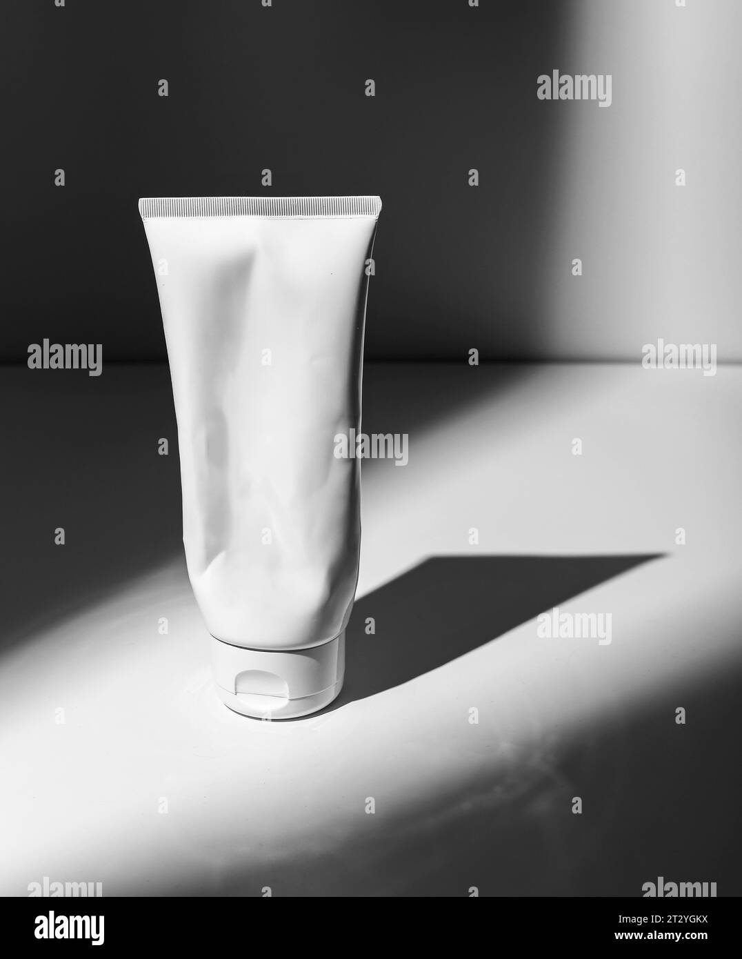Squeezed used cream tube container in light and shadow Stock Photo - Alamy